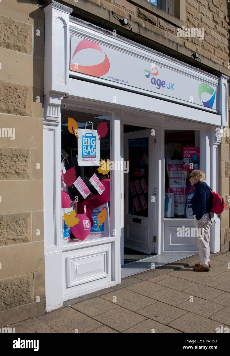 A woman looking in the window of the Age Concern shop in Bakewell ...