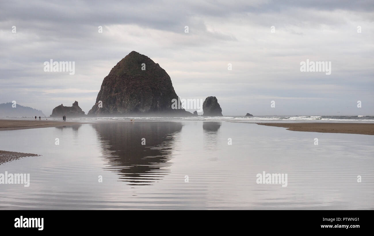 Haystack Rock reflected in the tide pools of Cannon Beach, Oregon at ...