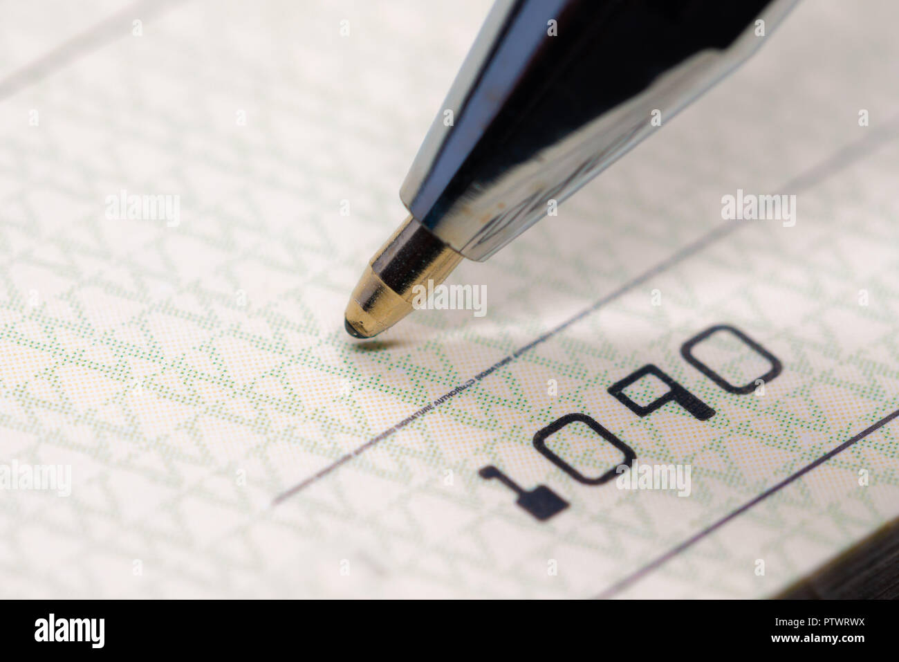 Upclose view of a pen about to sign a check Stock Photo - Alamy