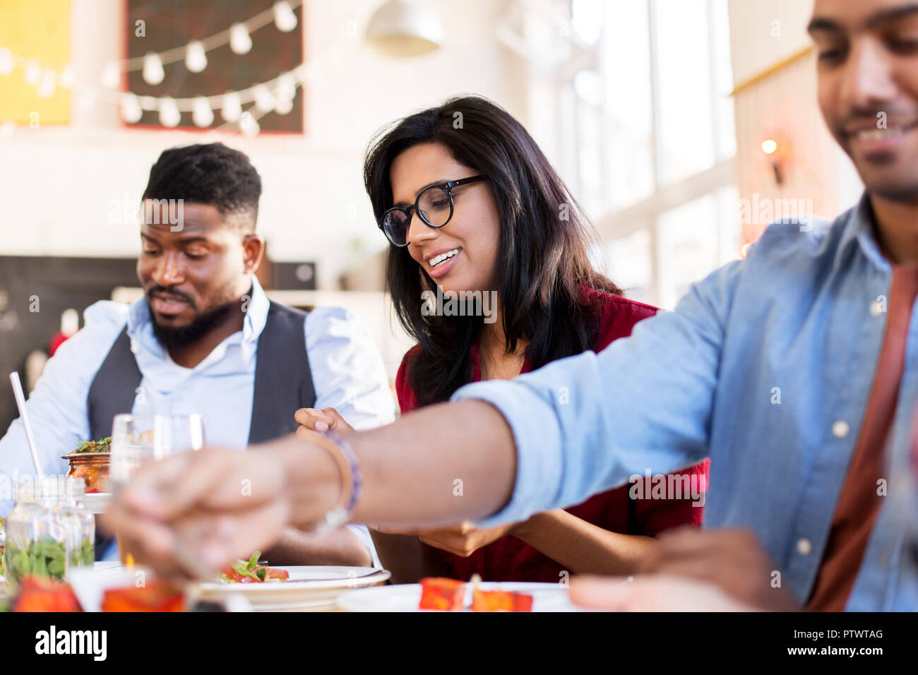 happy friends eating at restaurant Stock Photo - Alamy