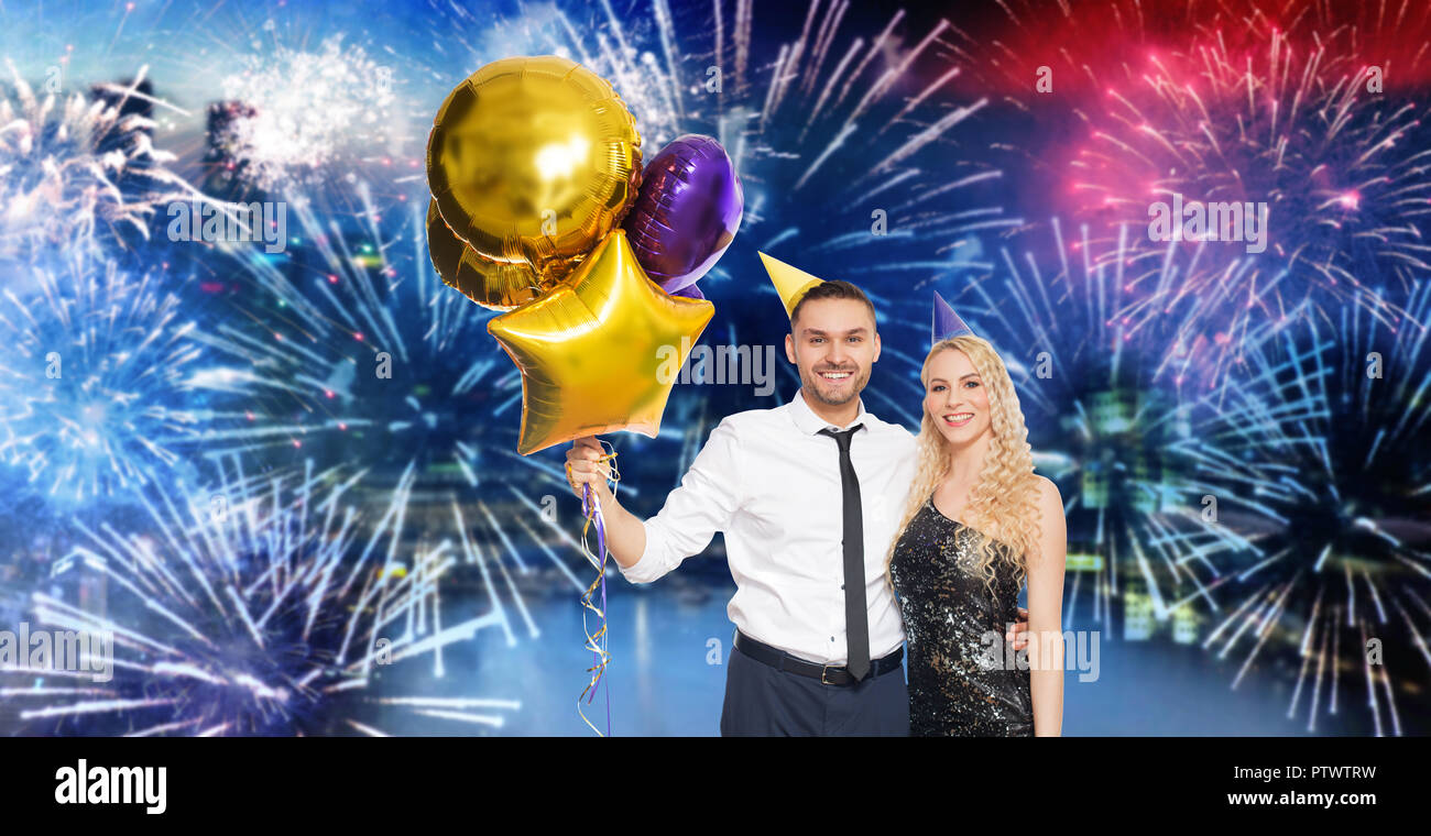 couple with party caps and balloons over firework Stock Photo - Alamy