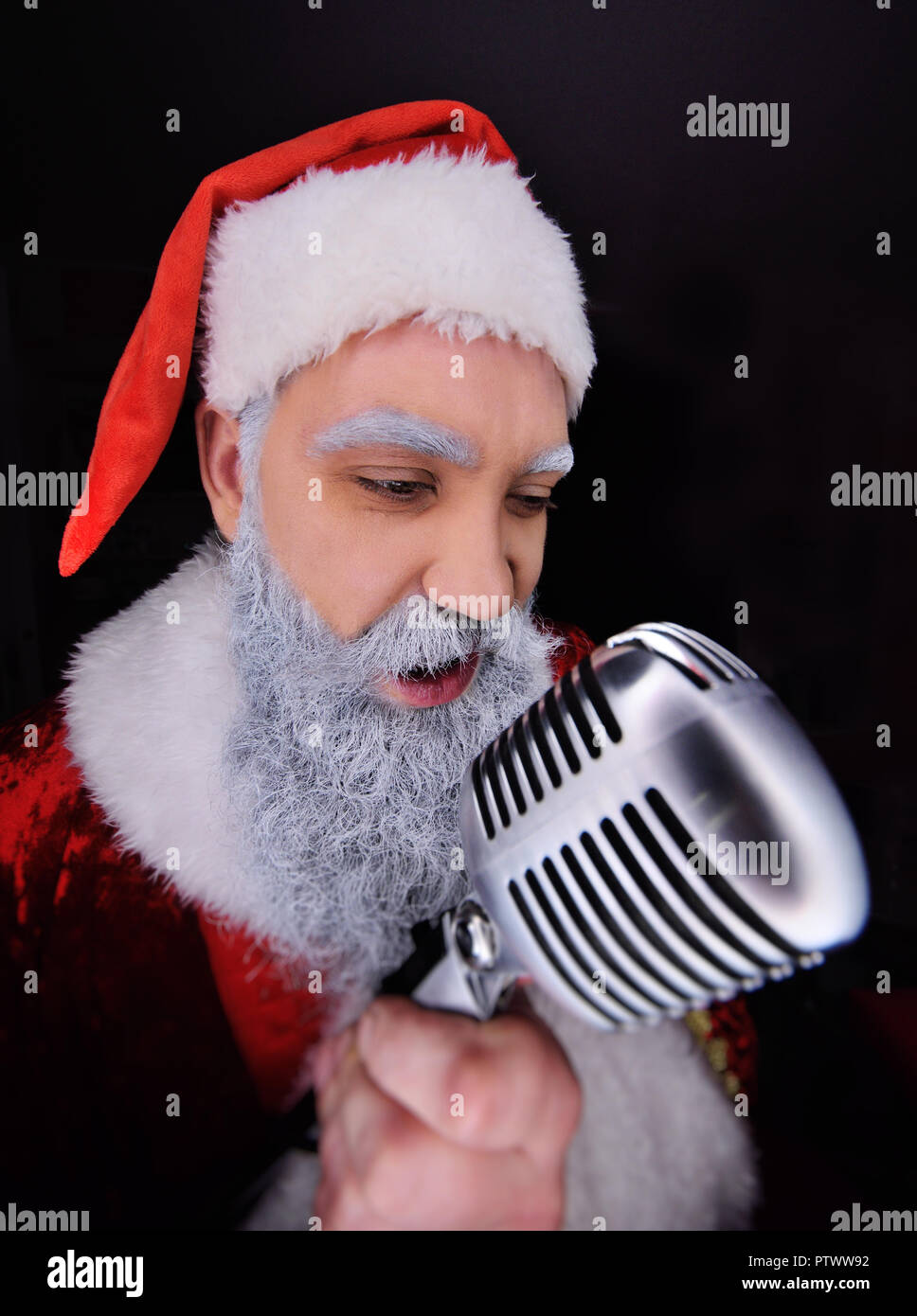santa claus with a microphone sings a song on a dark background Stock ...