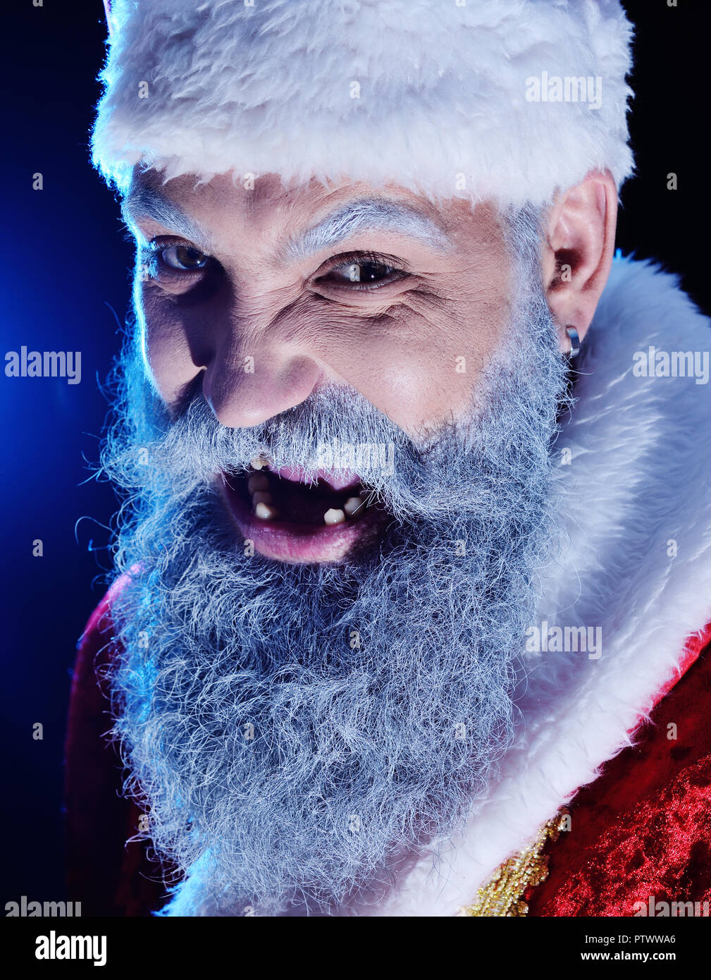 evil Santa Claus grimaces and scares a terrible face on a dark ...