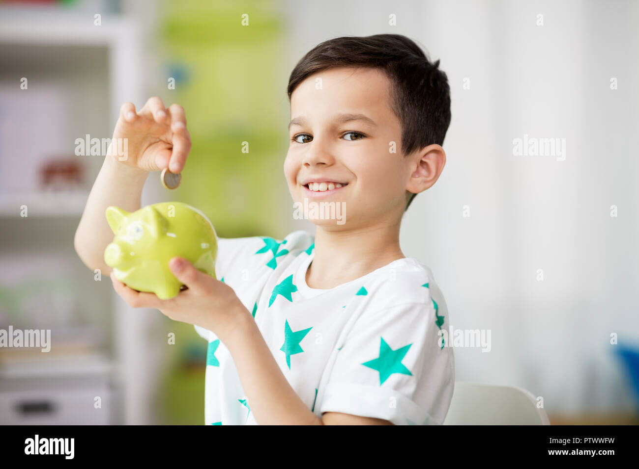 little boy putting coin into piggy bank at home Stock Photo - Alamy
