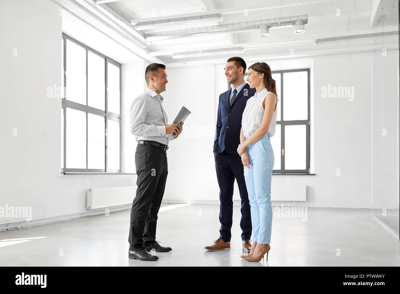 realtor with folder and customers at new office Stock Photo - Alamy