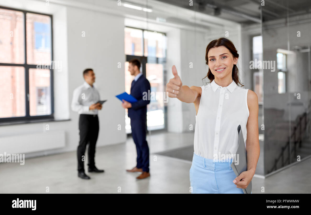 realtor with folder showing thumbs up at office Stock Photo - Alamy