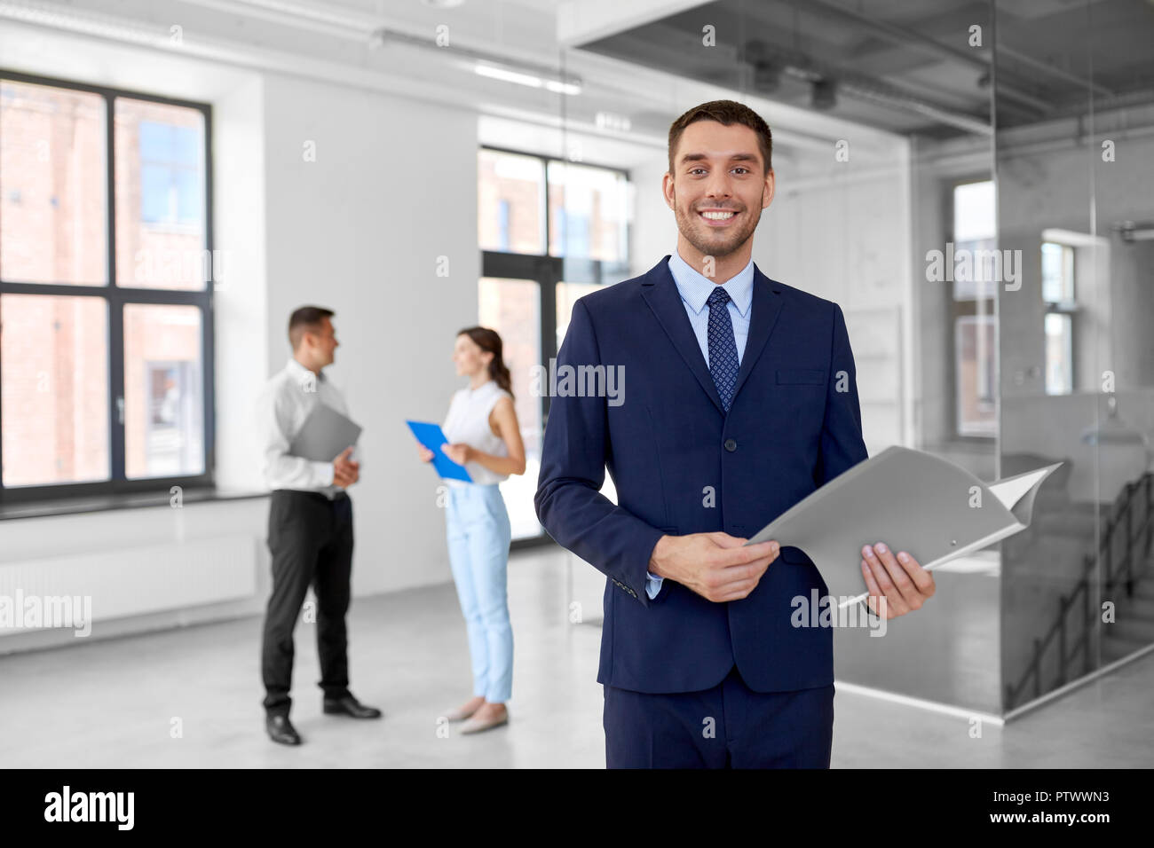 realtor with folder and customers at new office Stock Photo - Alamy