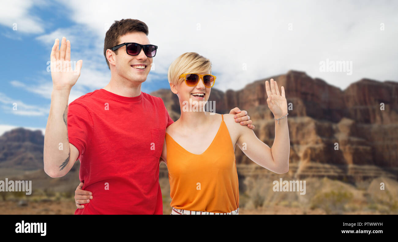 couple in sunglasses hugging and waving hands Stock Photo - Alamy