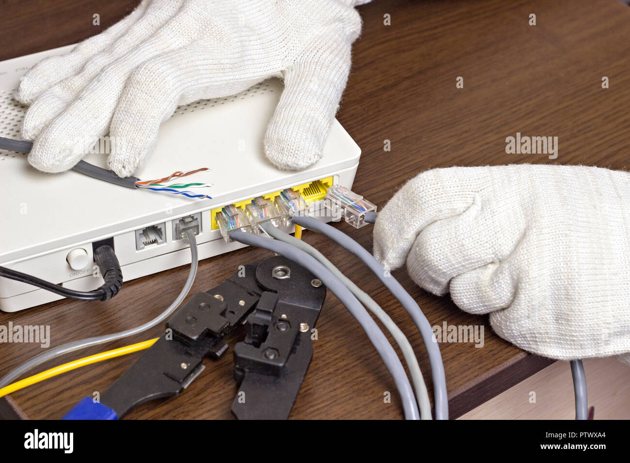 A man connects a network cable to the modem, a close-up Stock Photo - Alamy