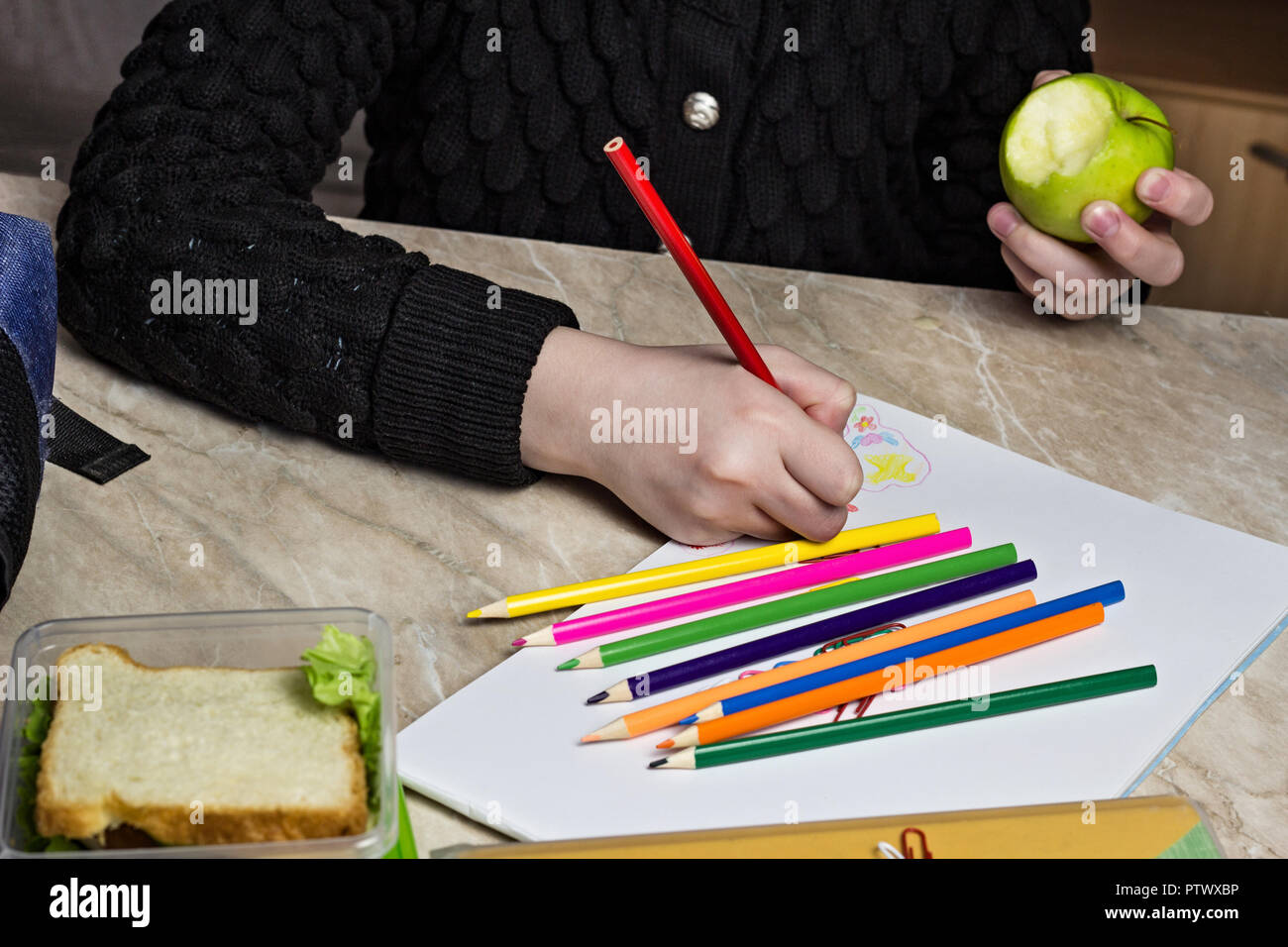 girl doing homework and eating apple, close up Stock Photo - Alamy