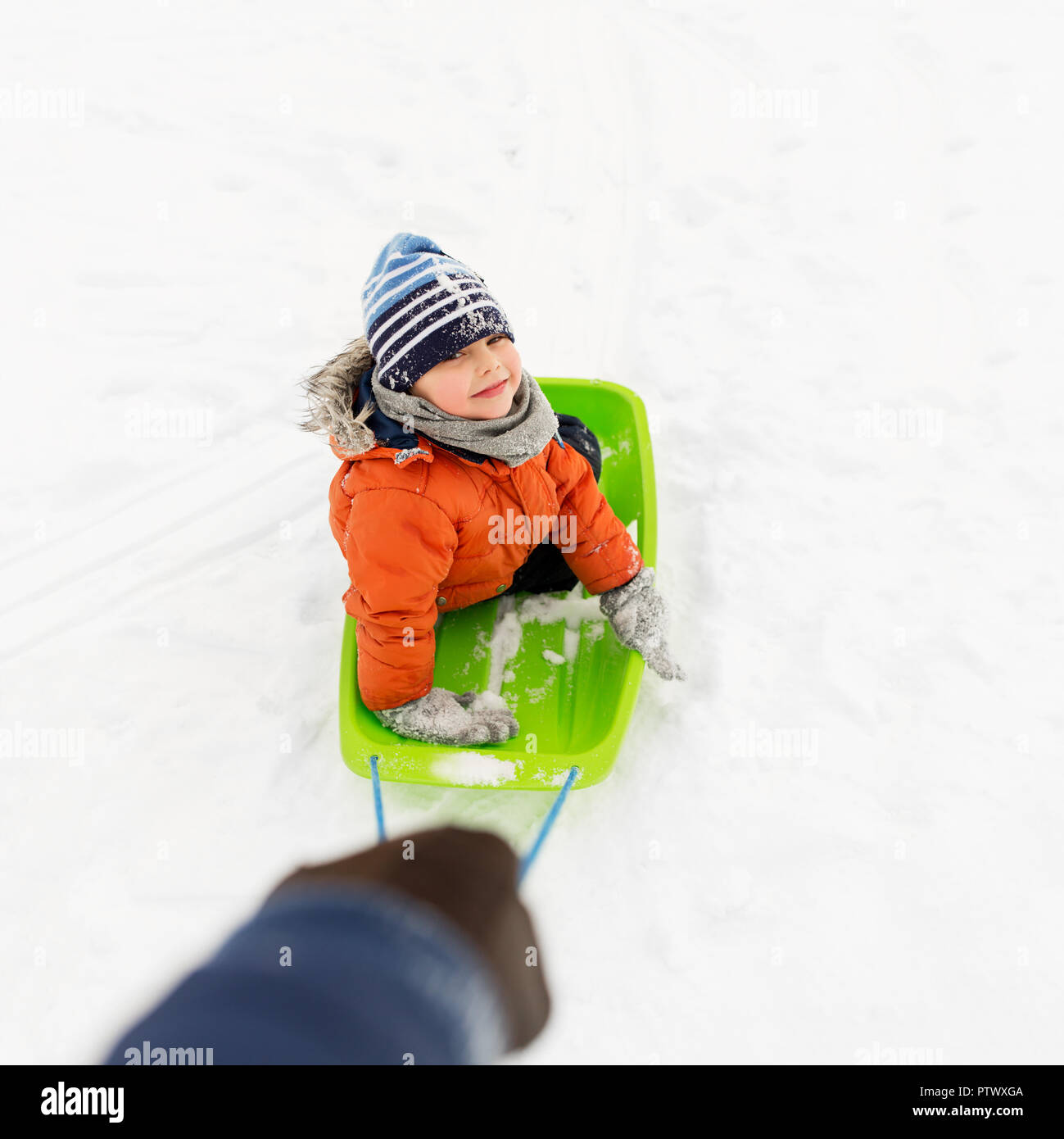 happy boy riding sled on snow in winter Stock Photo - Alamy