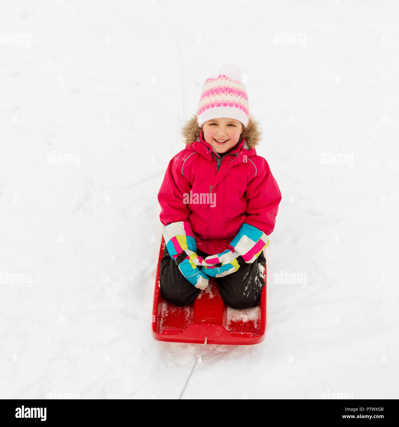 happy girl riding sled on snow in winter Stock Photo - Alamy