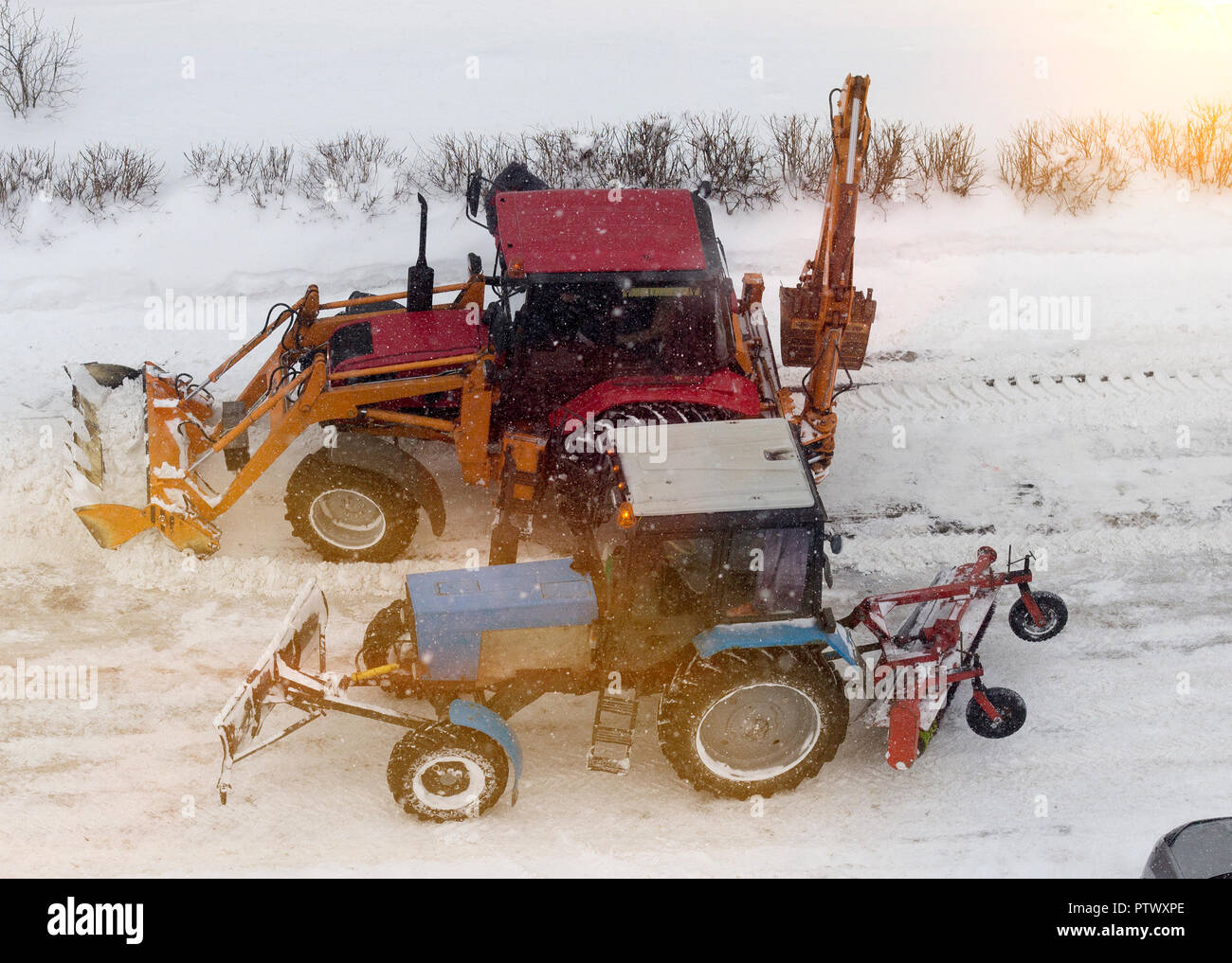 Red and blue tractor for snow cleaning Stock Photo - Alamy