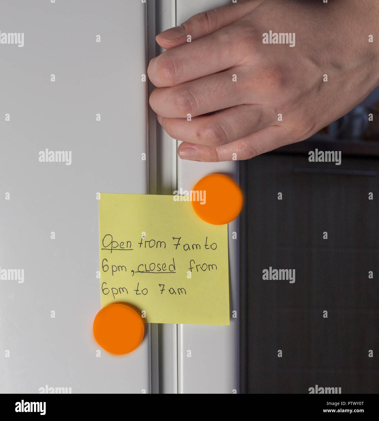 Hand opening refrigerator door and yellow sticker Stock Photo - Alamy