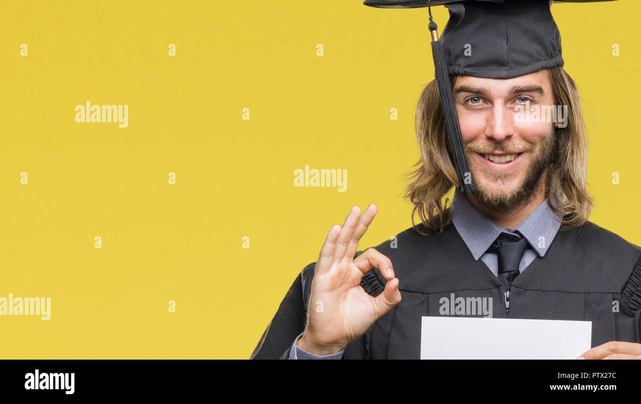 Young handsome graduate man with long hair holding blank paper over ...