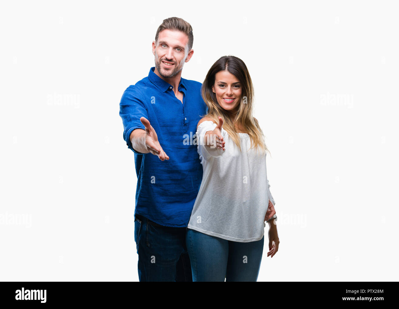 Young couple in love over isolated background smiling friendly offering ...