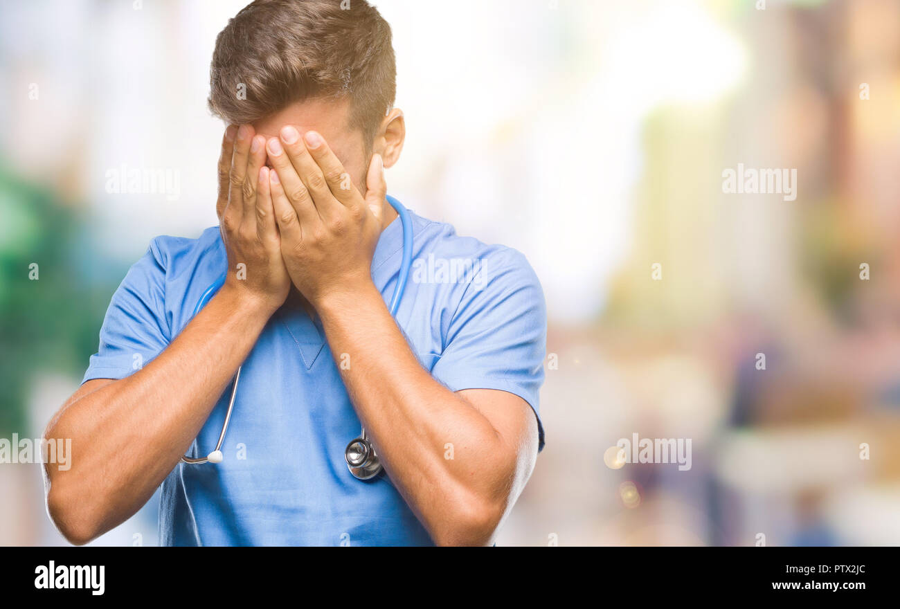 Young handsome doctor surgeon man over isolated background with sad ...