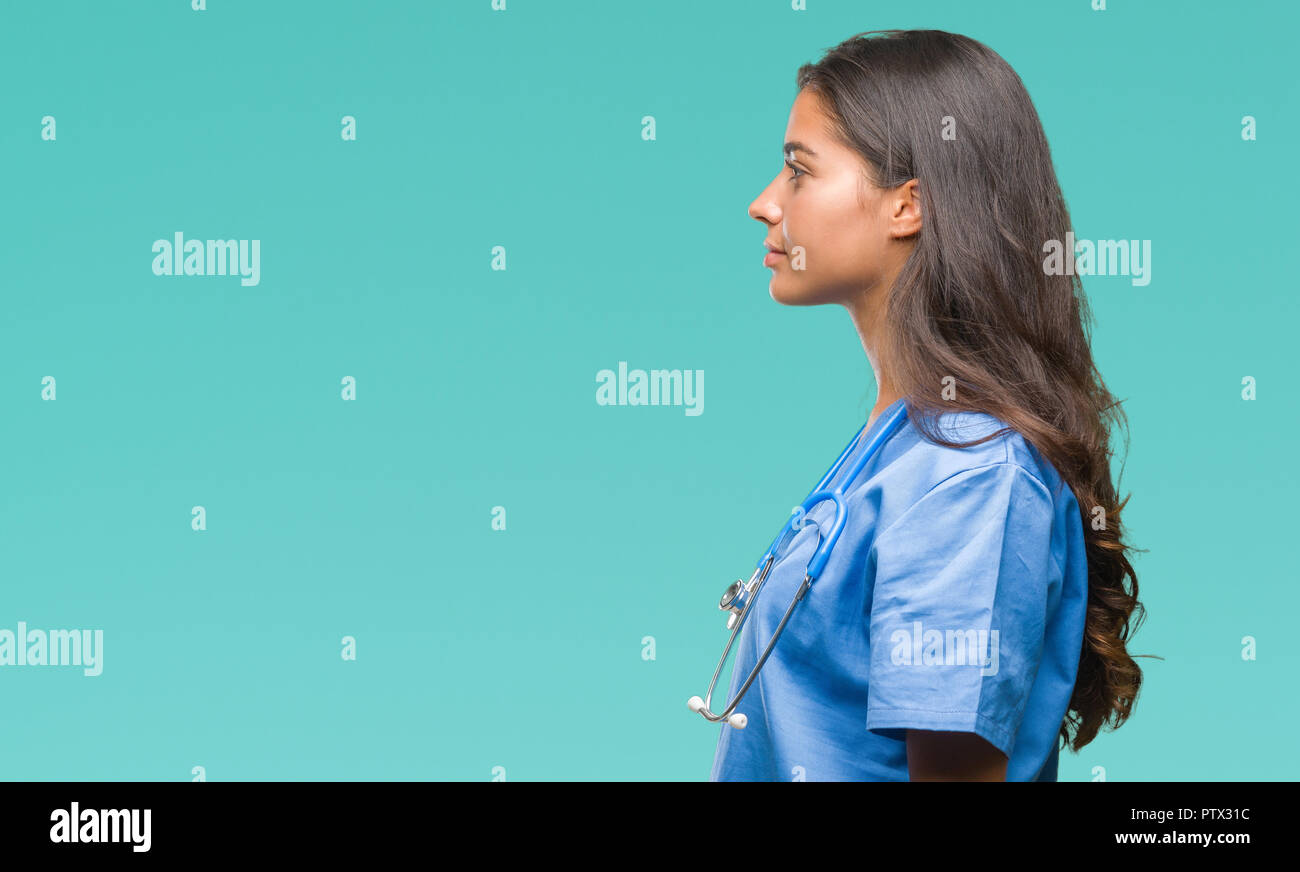 Young arab doctor surgeon woman over isolated background looking to ...