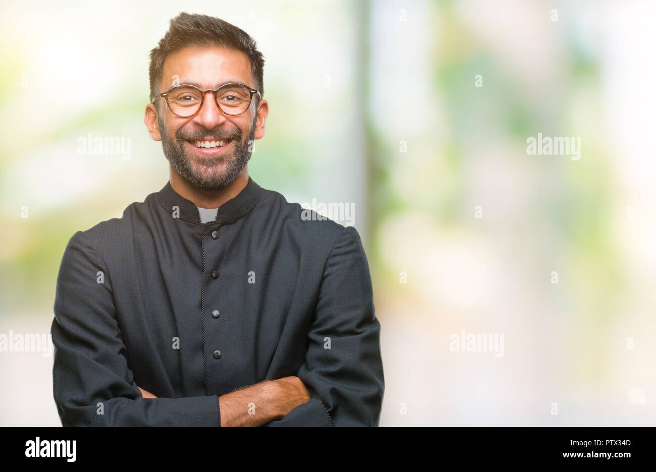 Adult hispanic catholic priest man over isolated background happy face ...