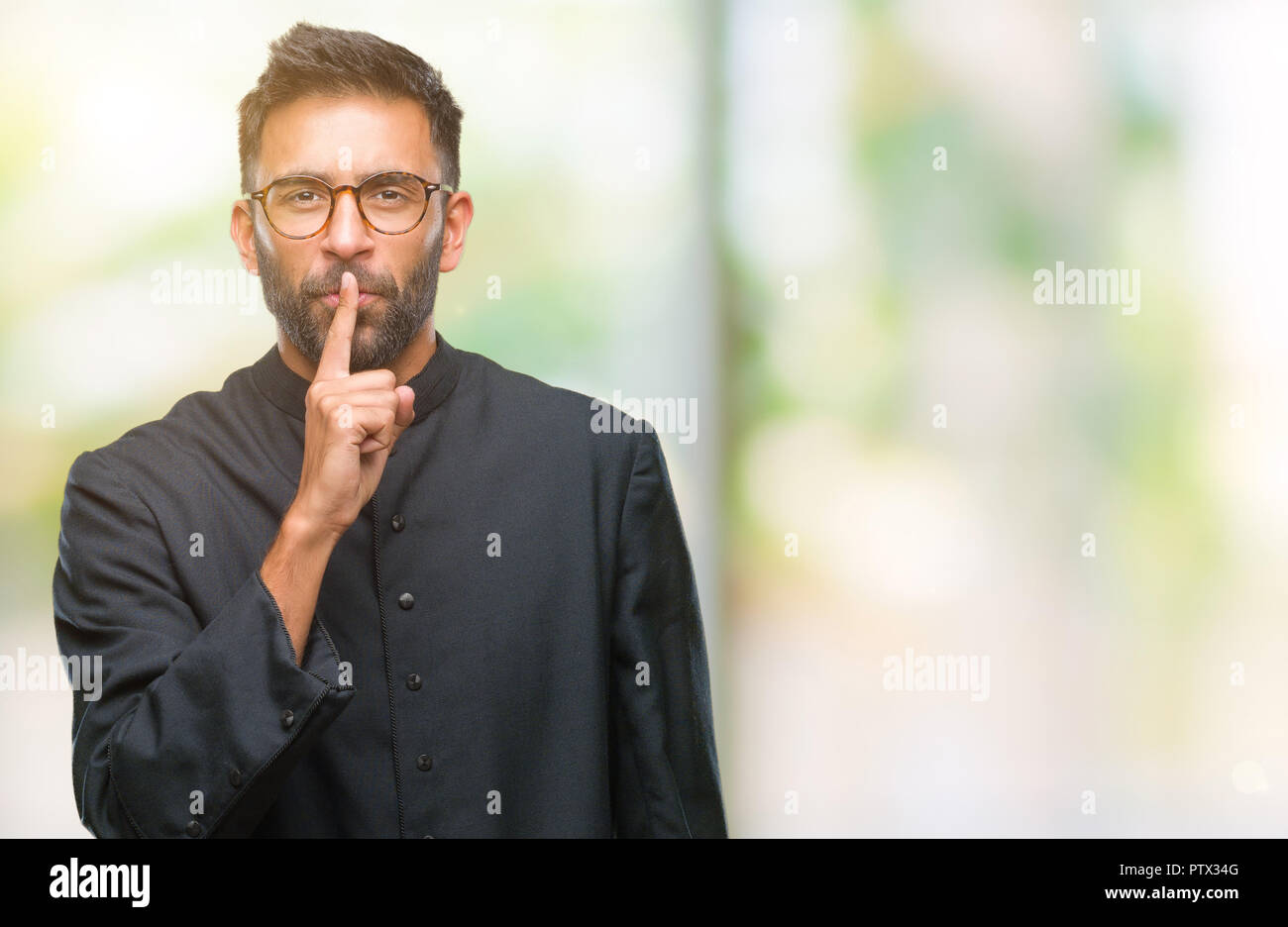 Adult hispanic catholic priest man over isolated background asking to ...