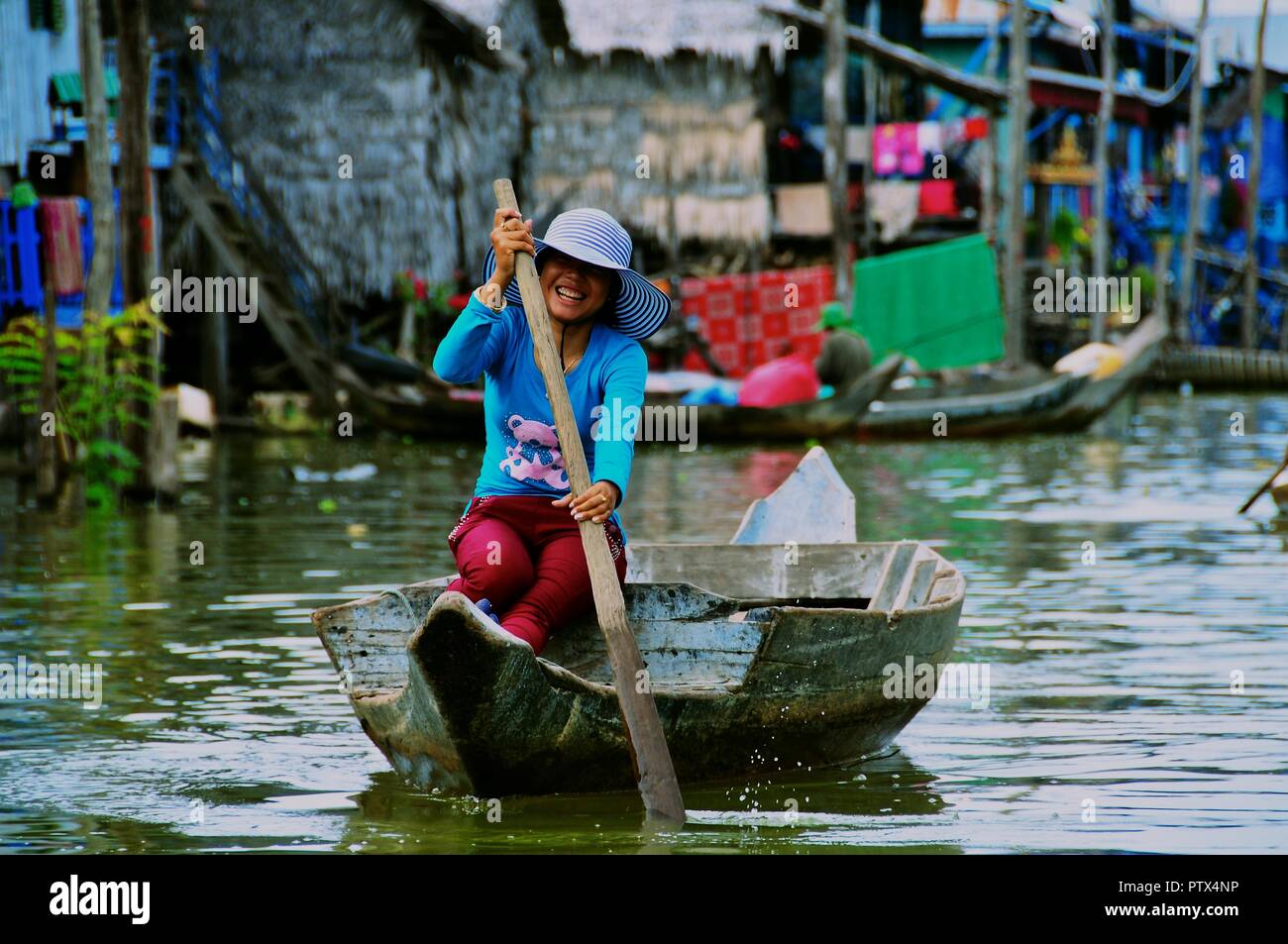 Happy lady paddling canoe in Cambodia Stock Photo - Alamy