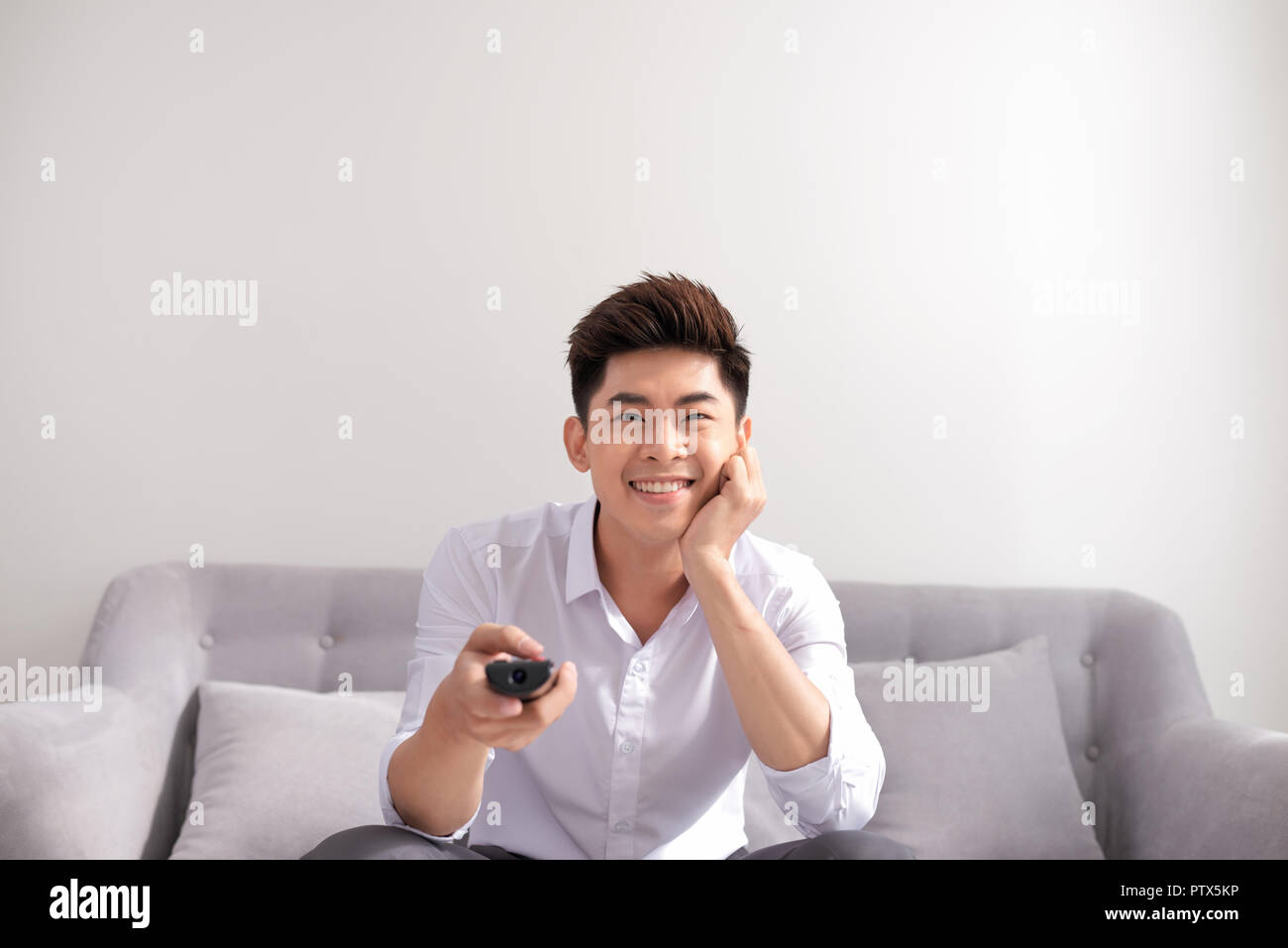 Shocking TV show. Handsome young man holding remote control and looking ...