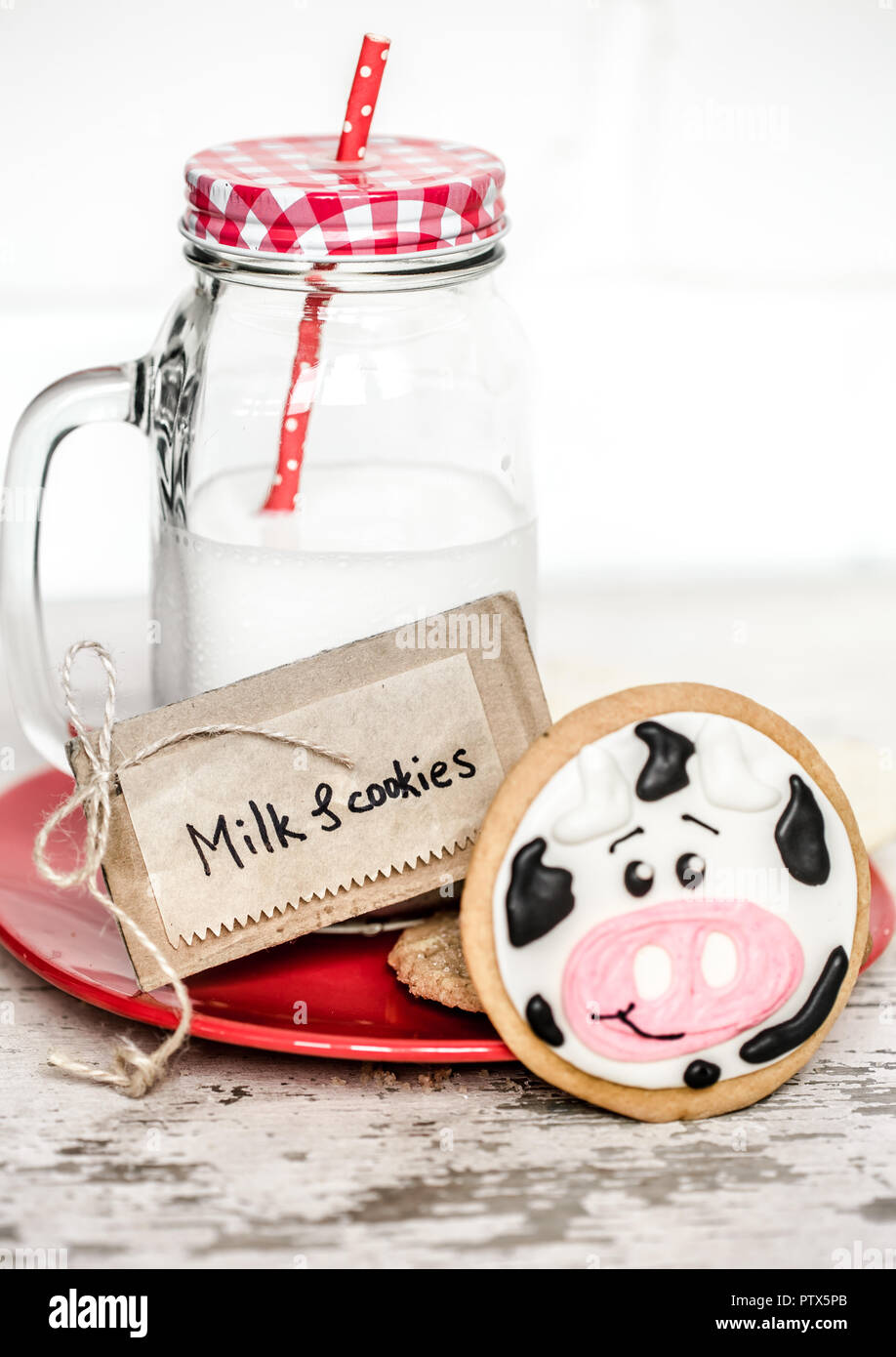 milk in a transparent jar with handle and baby biscuits as a cow on ...