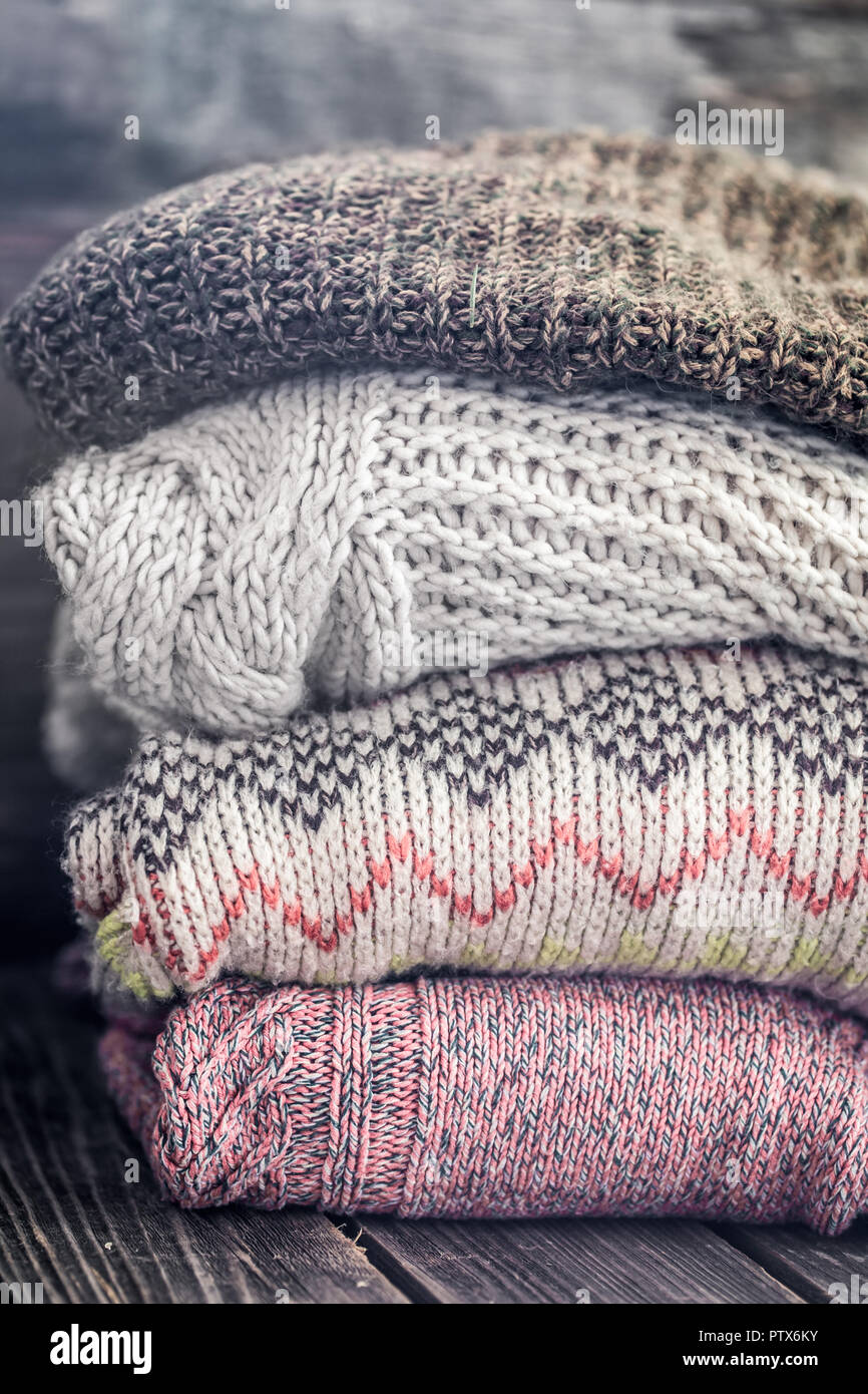 knitted warm cozy sweaters,on wooden background, concept of heat and ...