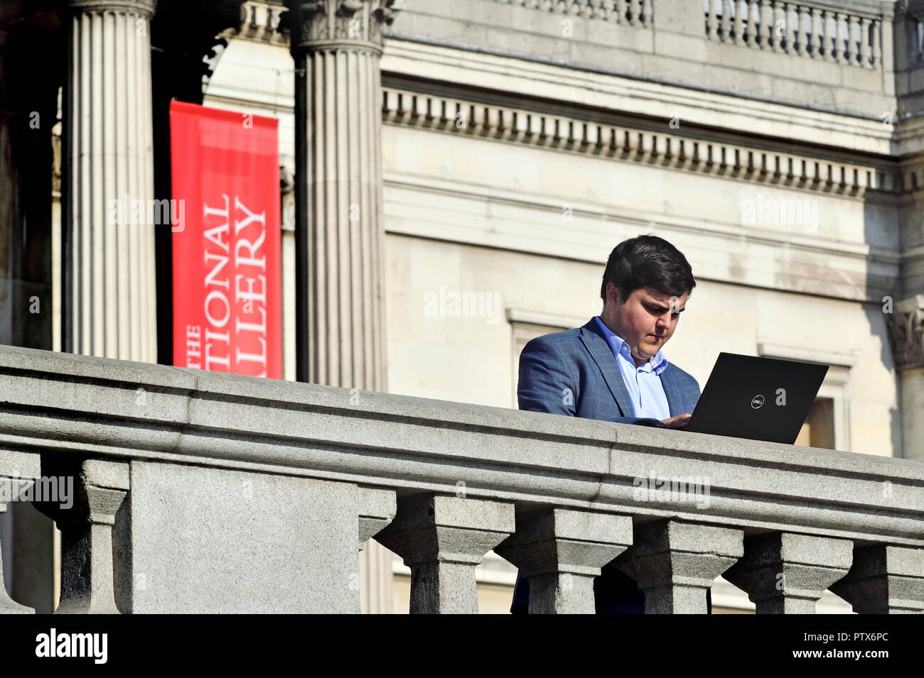 Businessman using his laptop computer in Trafalgar Square, London ...