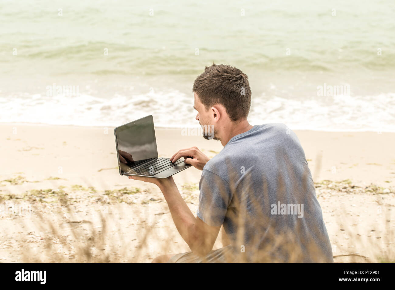 man running on the computer, in nature, to work on the beach Stock ...