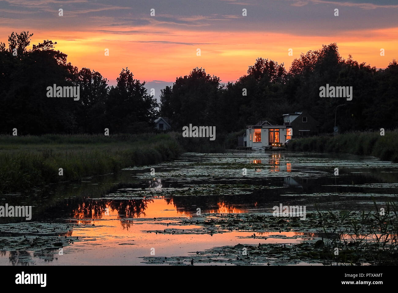 Dutch houseboat at a colorful sunset Stock Photo - Alamy