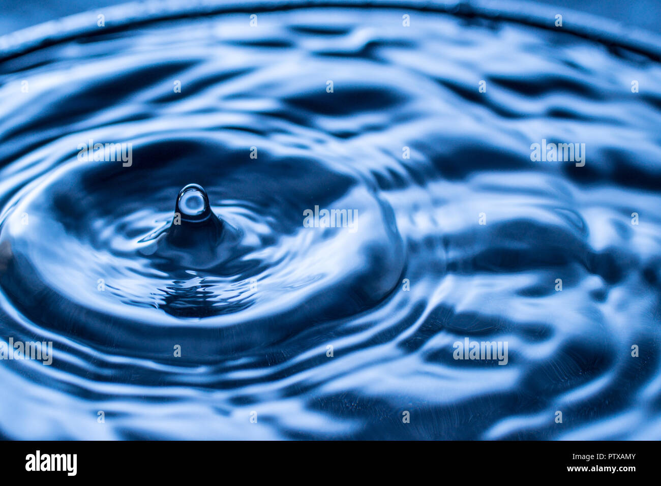 water drop splash in a glass blue colored Stock Photo - Alamy