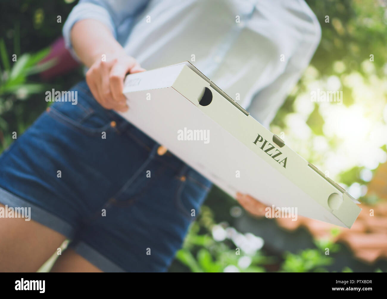 Pizza delivery woman holding pizza box Stock Photo - Alamy