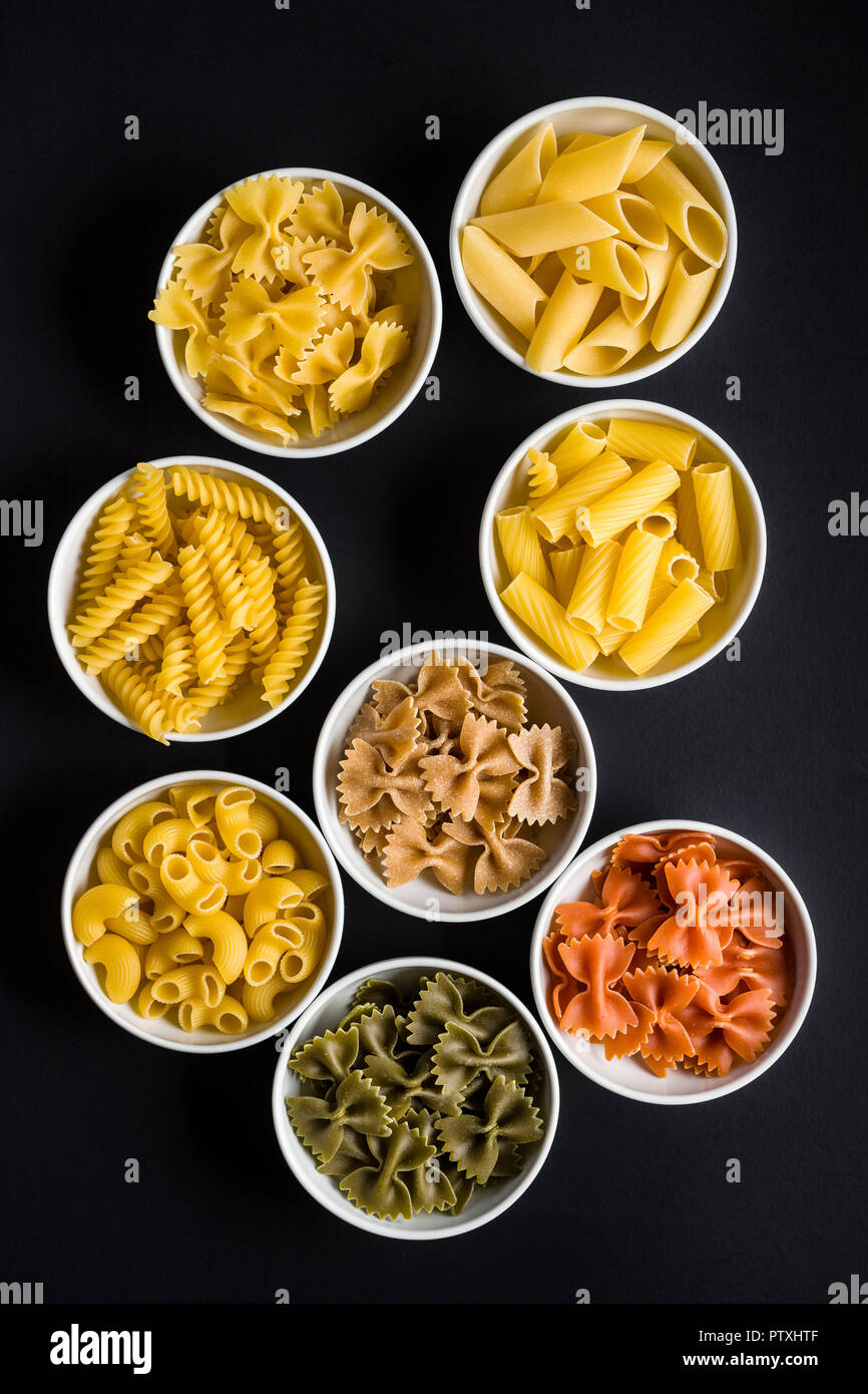Various types of italian pasta in bowl on black background Stock Photo ...
