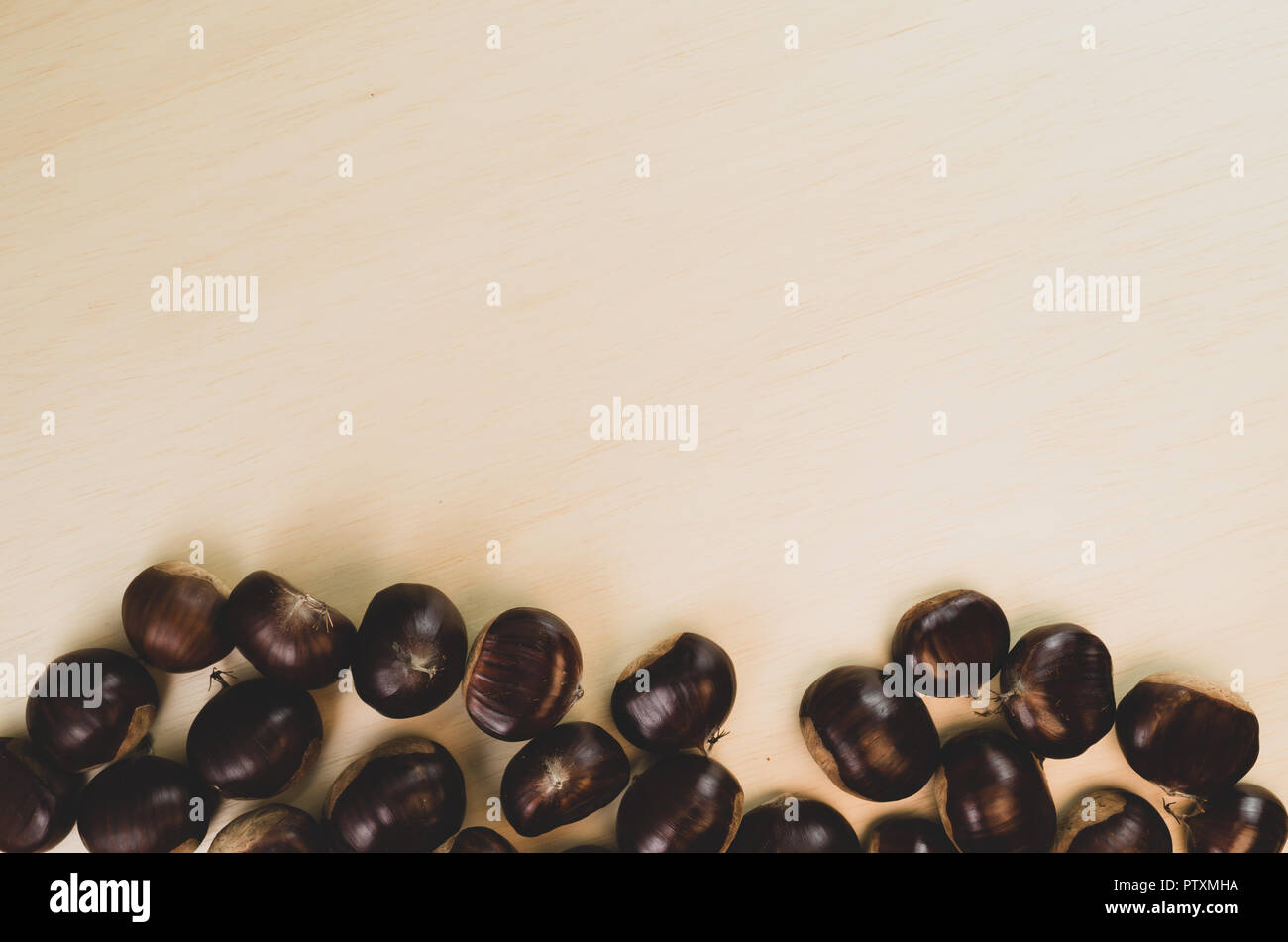 chestnuts on a light wooden surface - organic fruits concepts Stock ...