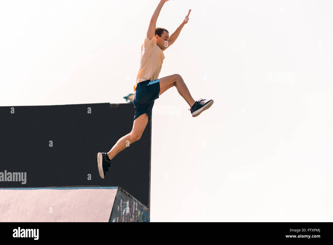 Young man in action while jumping of the wall in skatepark Stock Photo ...