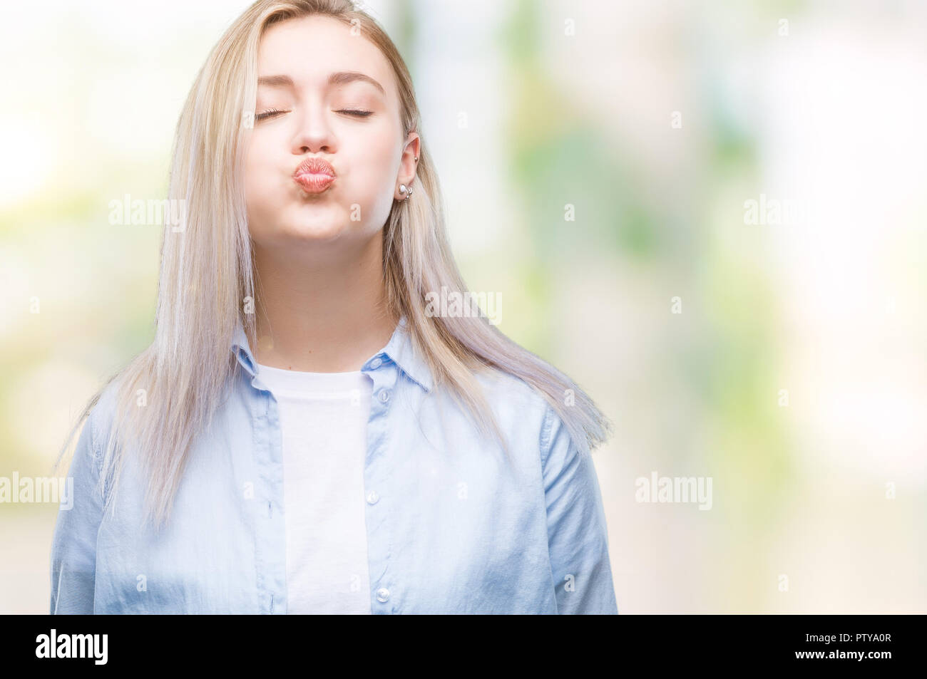 Young blonde woman over isolated background puffing cheeks with funny ...