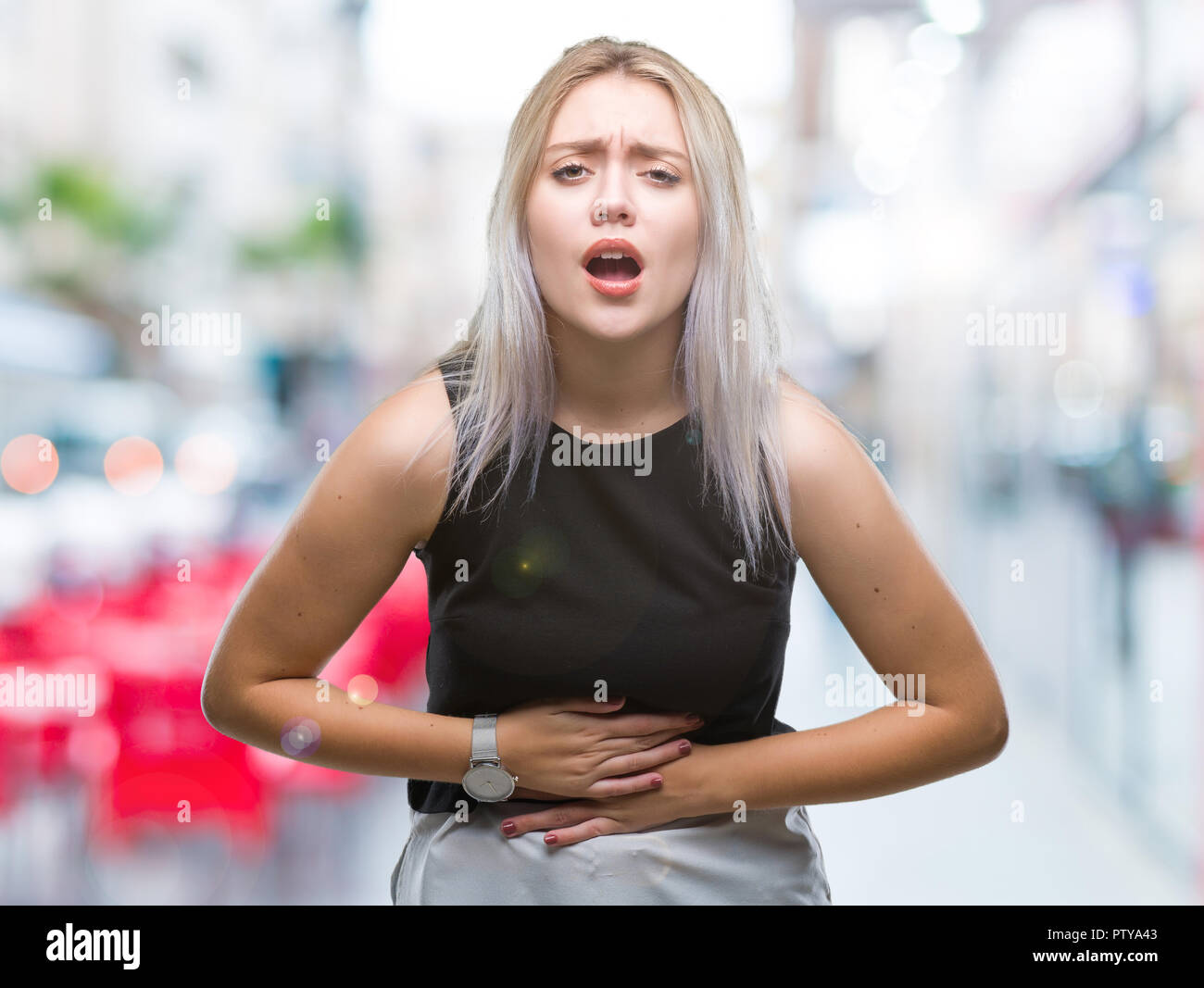 Young blonde woman over isolated background with hand on stomach ...