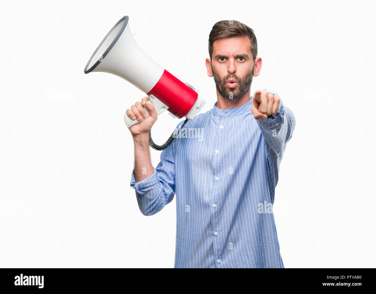 Young handsome man yelling through megaphone over isolated background ...