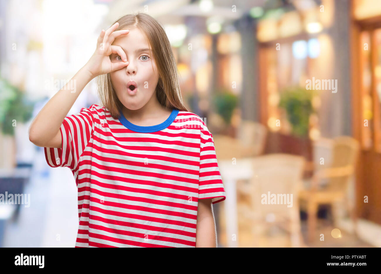 Young beautiful girl over isolated background doing ok gesture shocked ...