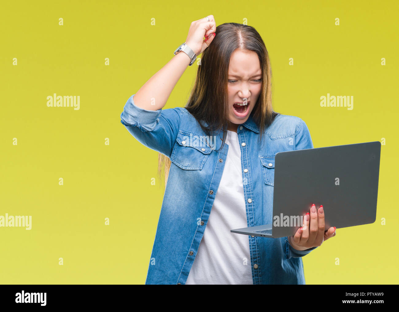Young caucasian woman using laptop over isolated background annoyed and ...