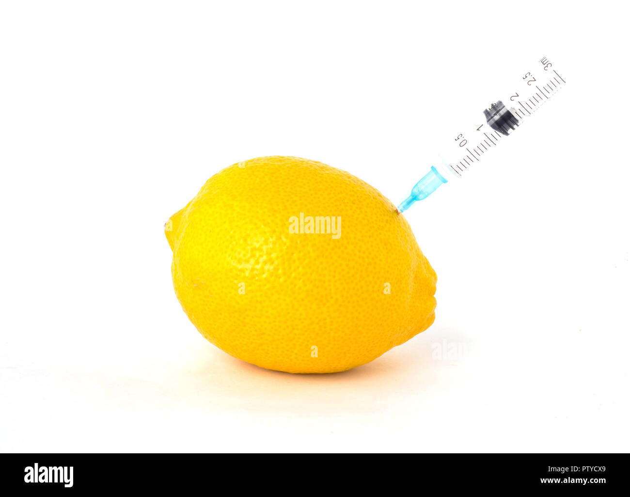 Lemon on a white background in which syringe is injected with gmo and ...