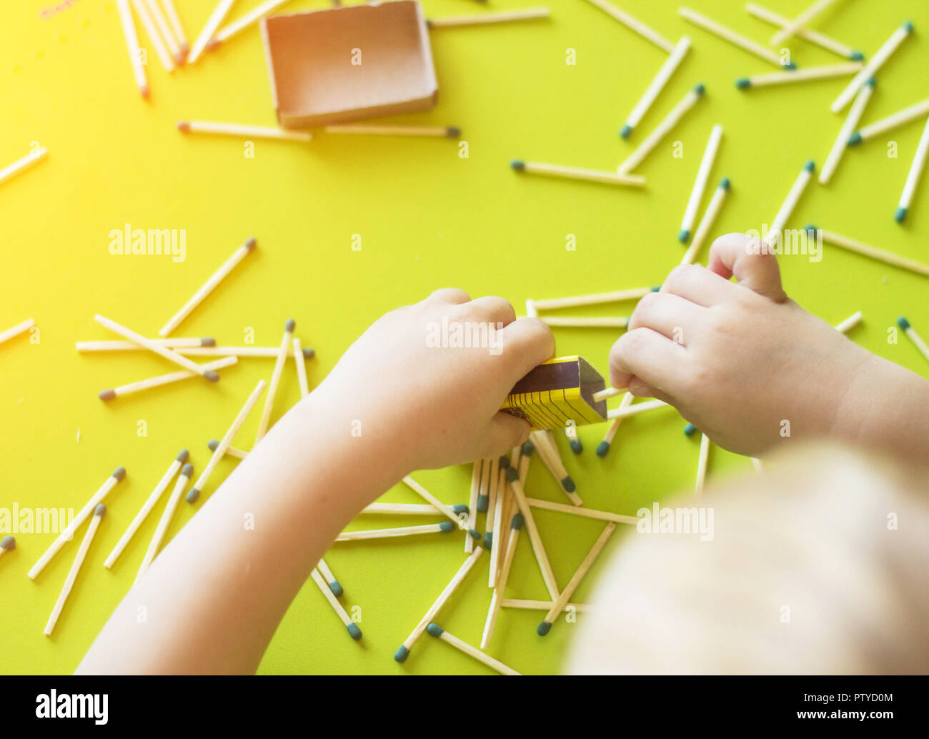 A small child plays with matches, matches matches into boxes, close-ups ...