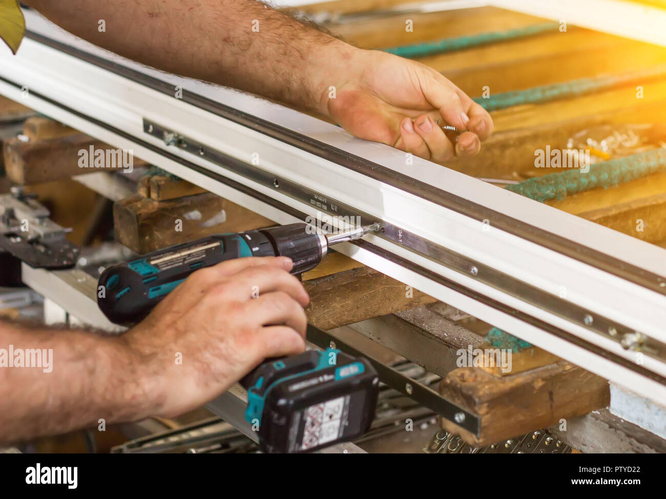 Production of pvc windows, a man screws a screwdriver into a pvc window ...