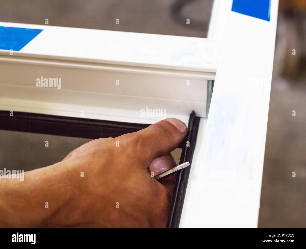 Production of pvc windows, the worker installs the sealing rubber in ...