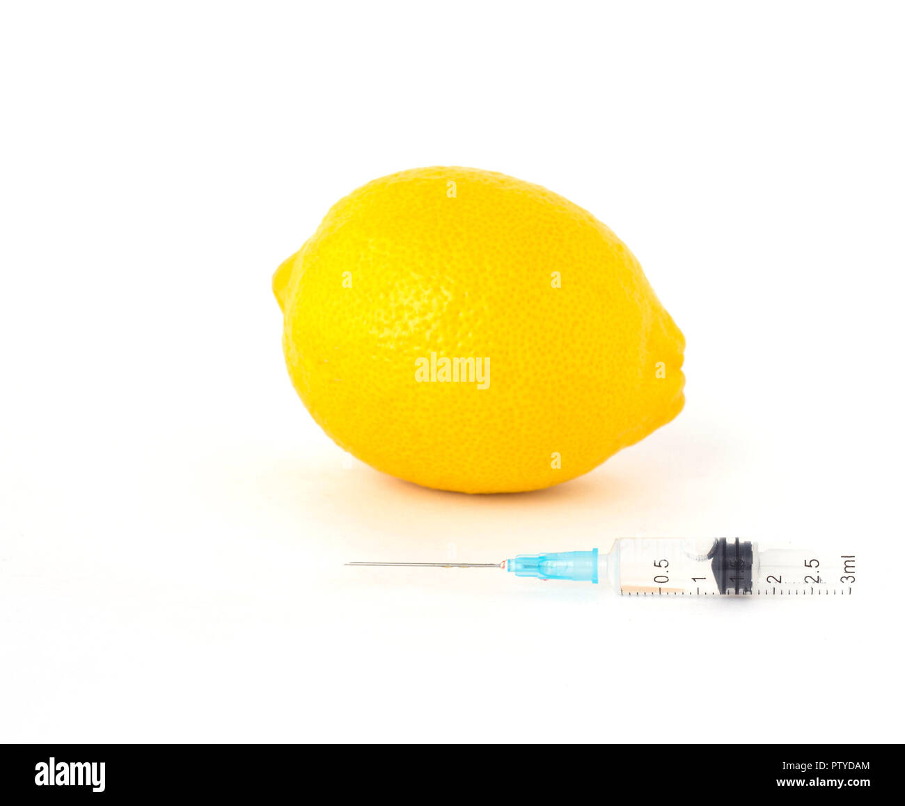 lemon on white background next to which is a syringe with gmo and ...