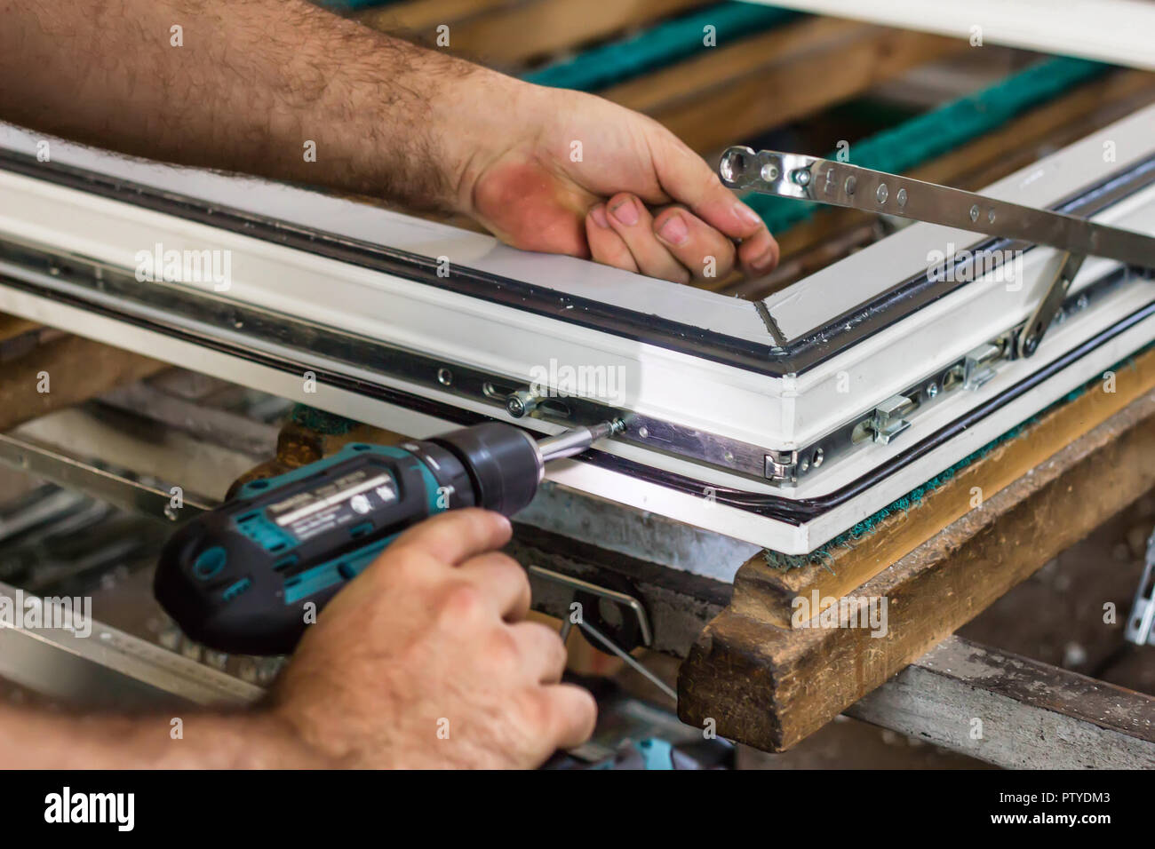 Production of pvc windows, a man screws a screwdriver into a pvc window ...
