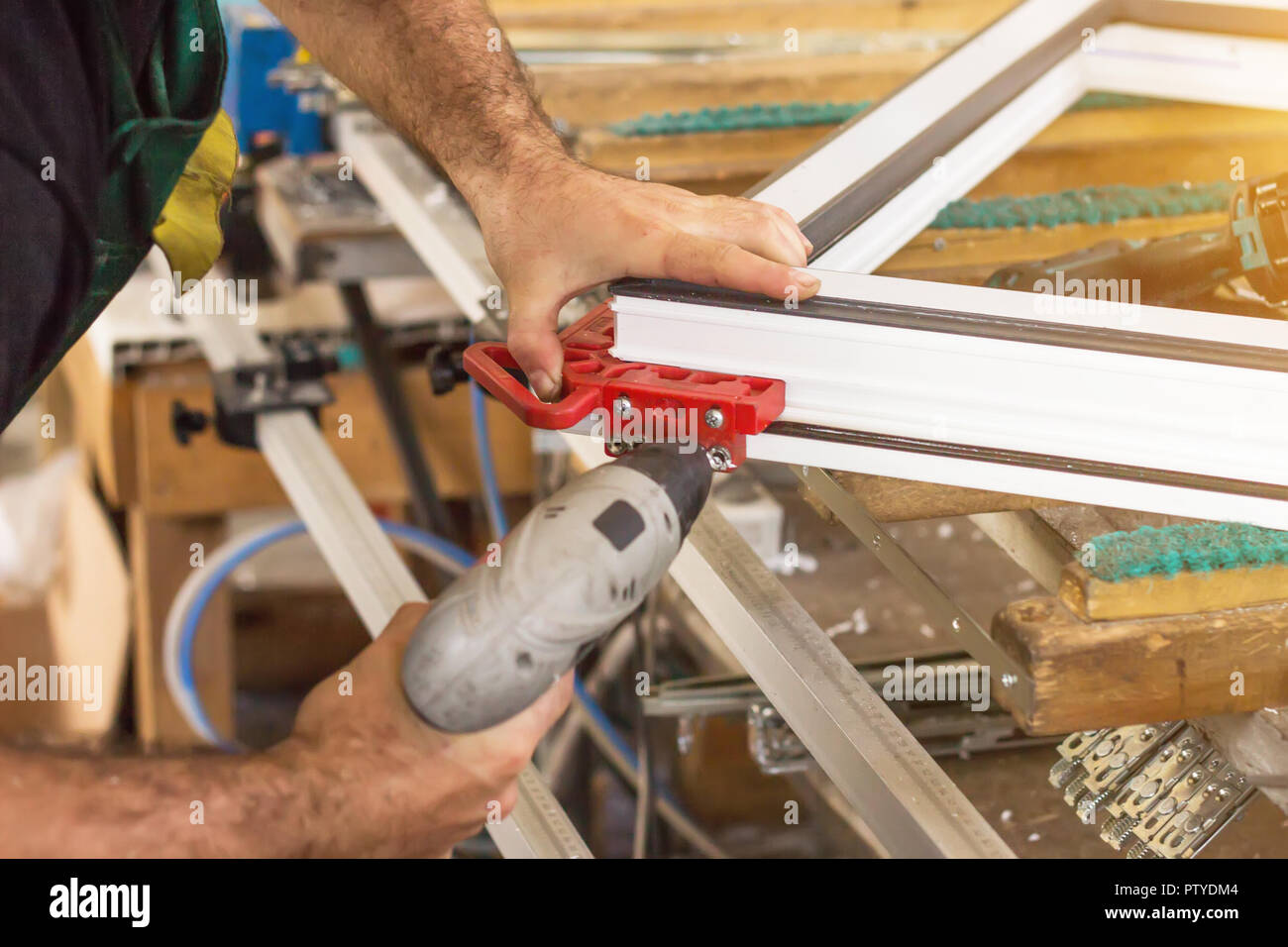 Production of pvc windows, a man screws a screwdriver into a pvc window ...