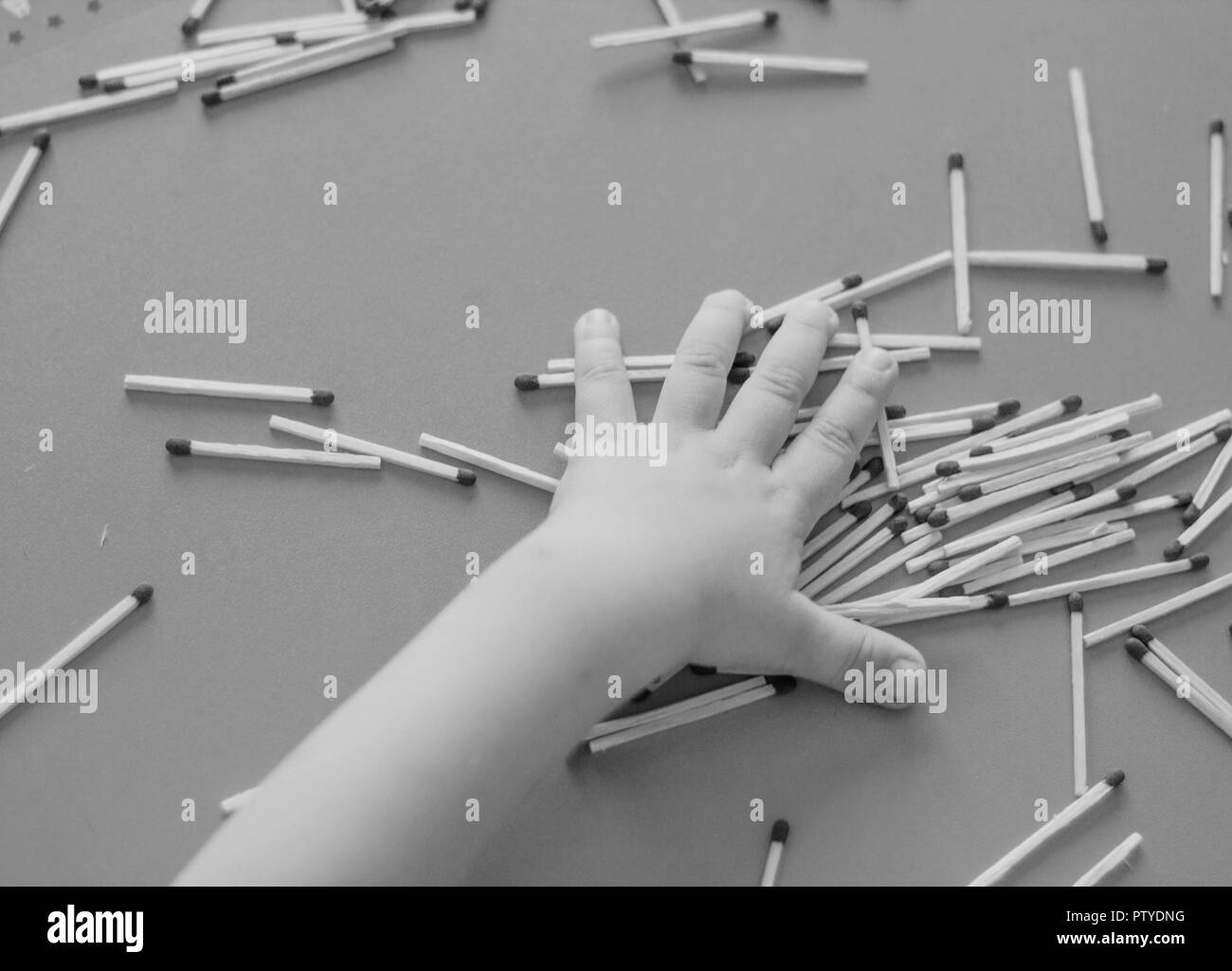 A small child plays with matches, takes matches from the table, close ...