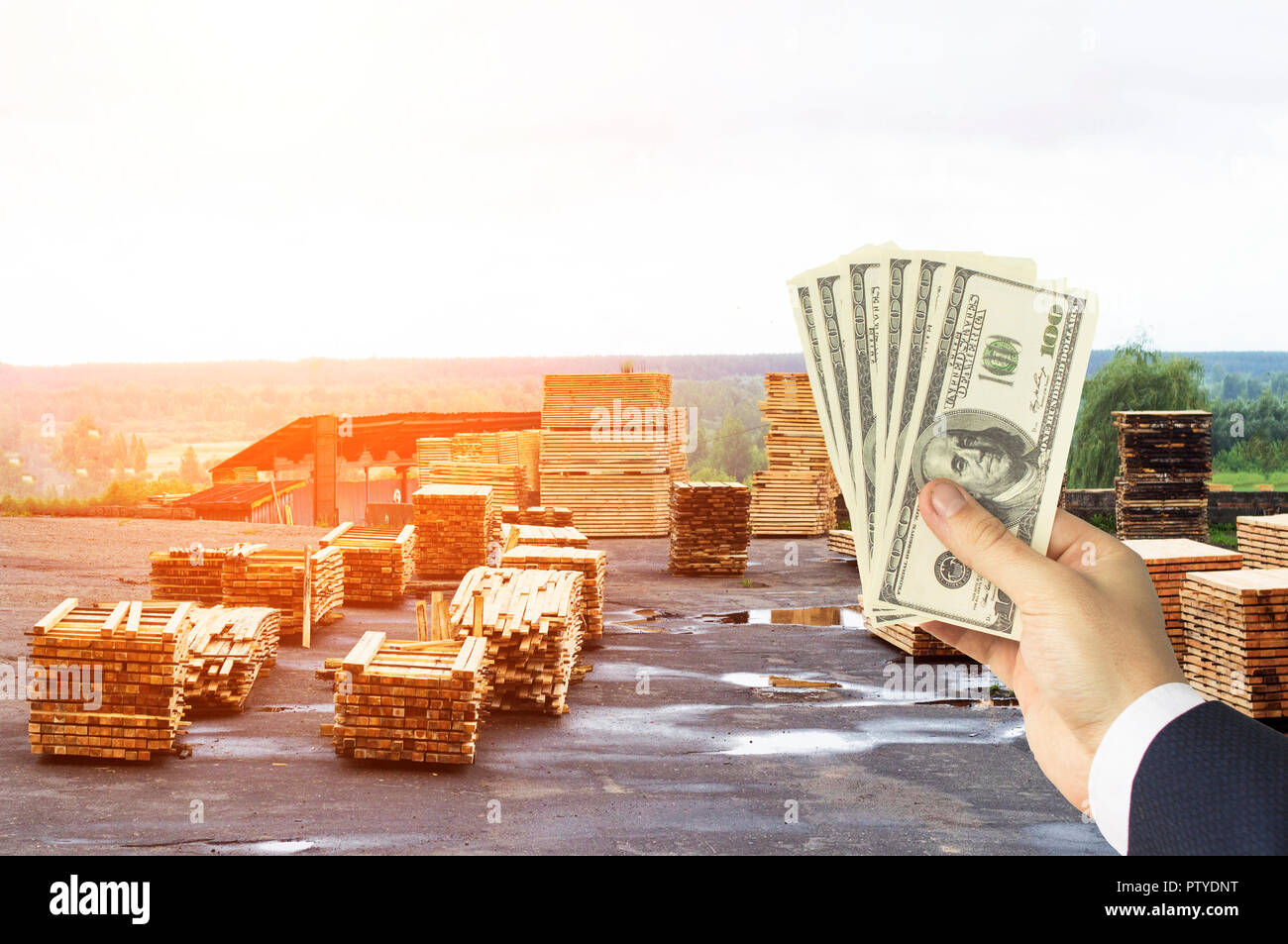 Hand with money dollars against the background of a warehouse with ...